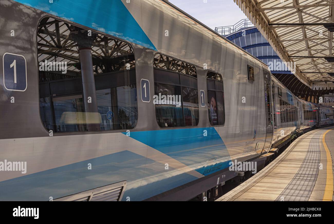A close-up of railway carriages resting beneath a historic canopy. The ...