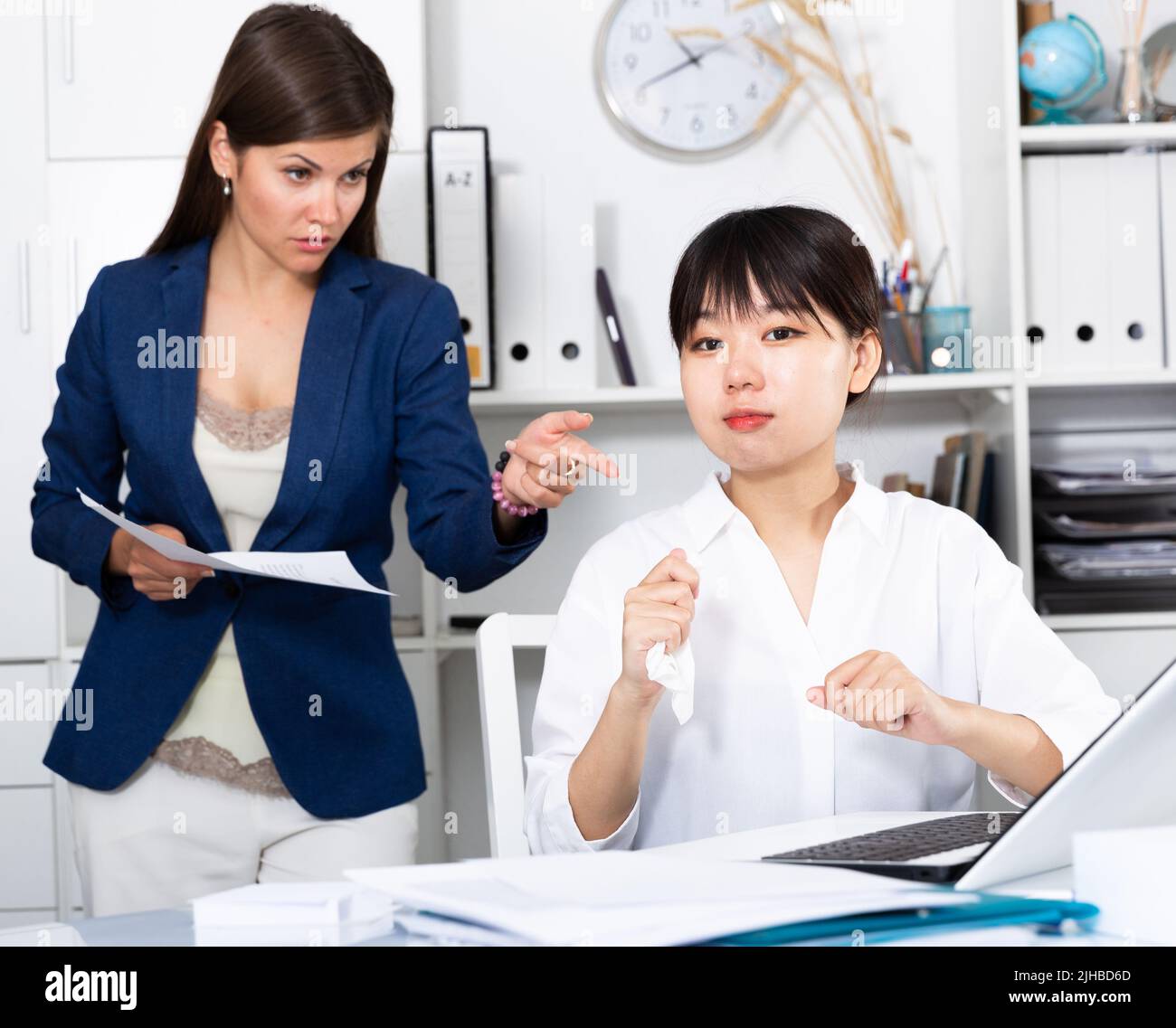 Upset asian woman with angry boss Stock Photo - Alamy