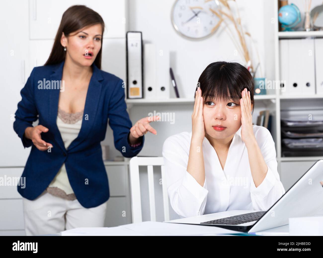 Upset asian woman with angry boss Stock Photo - Alamy