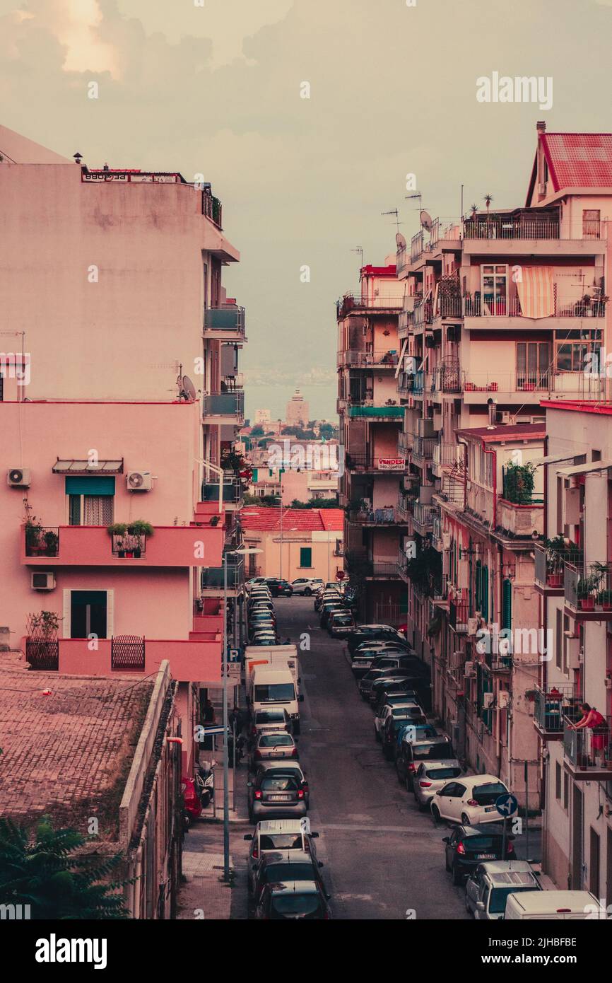 A vertical shot of a street in Messina filled with cars between ...