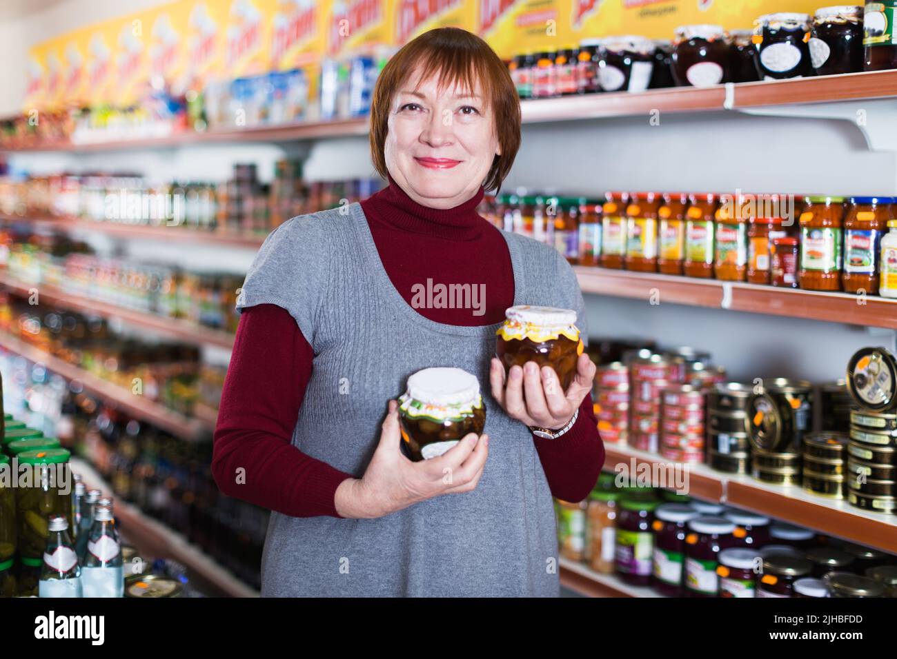 female customer choosing canned jar of jam Stock Photo - Alamy