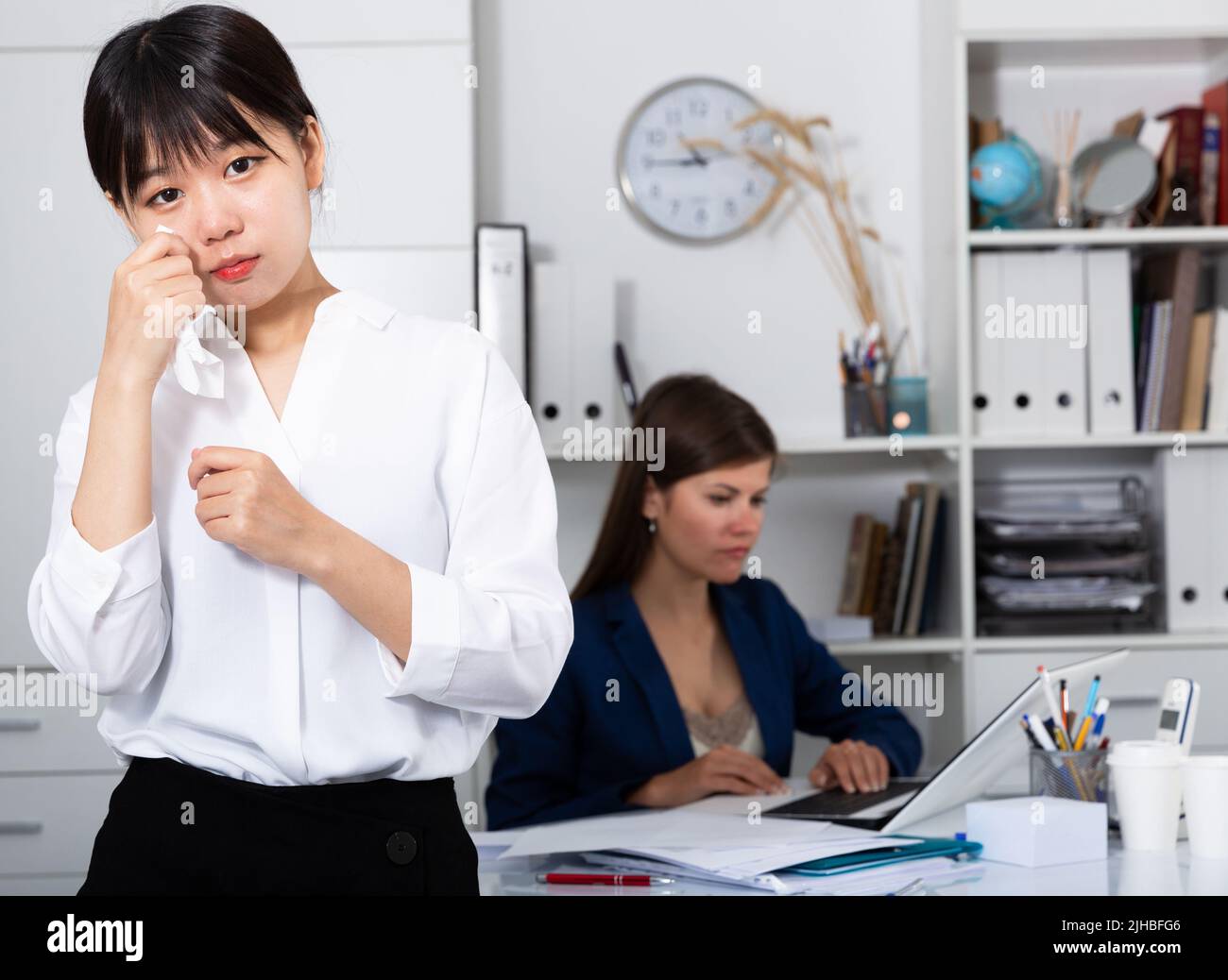 Frustrated asian woman standing at office Stock Photo - Alamy