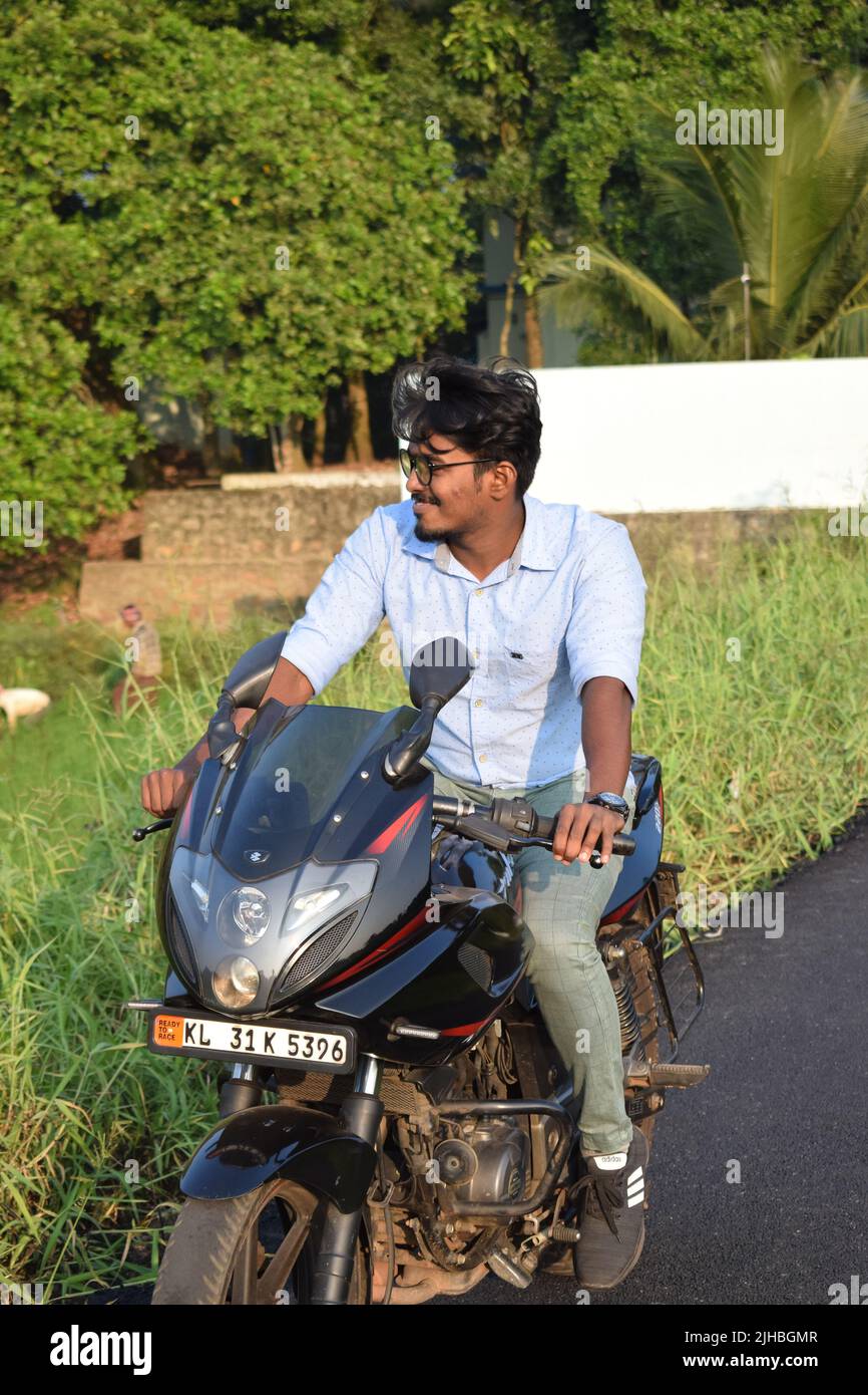 An indian young man riding a motorcycle near a paddy field Stock Photo ...