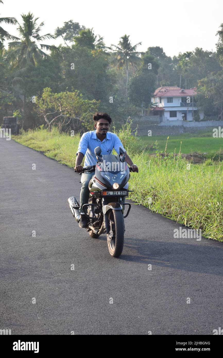 An indian young man riding a motorcycle near a paddy field Stock Photo ...