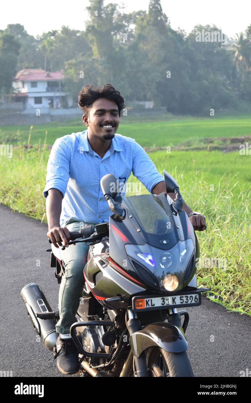 An indian young man riding a motorcycle near a paddy field Stock Photo ...