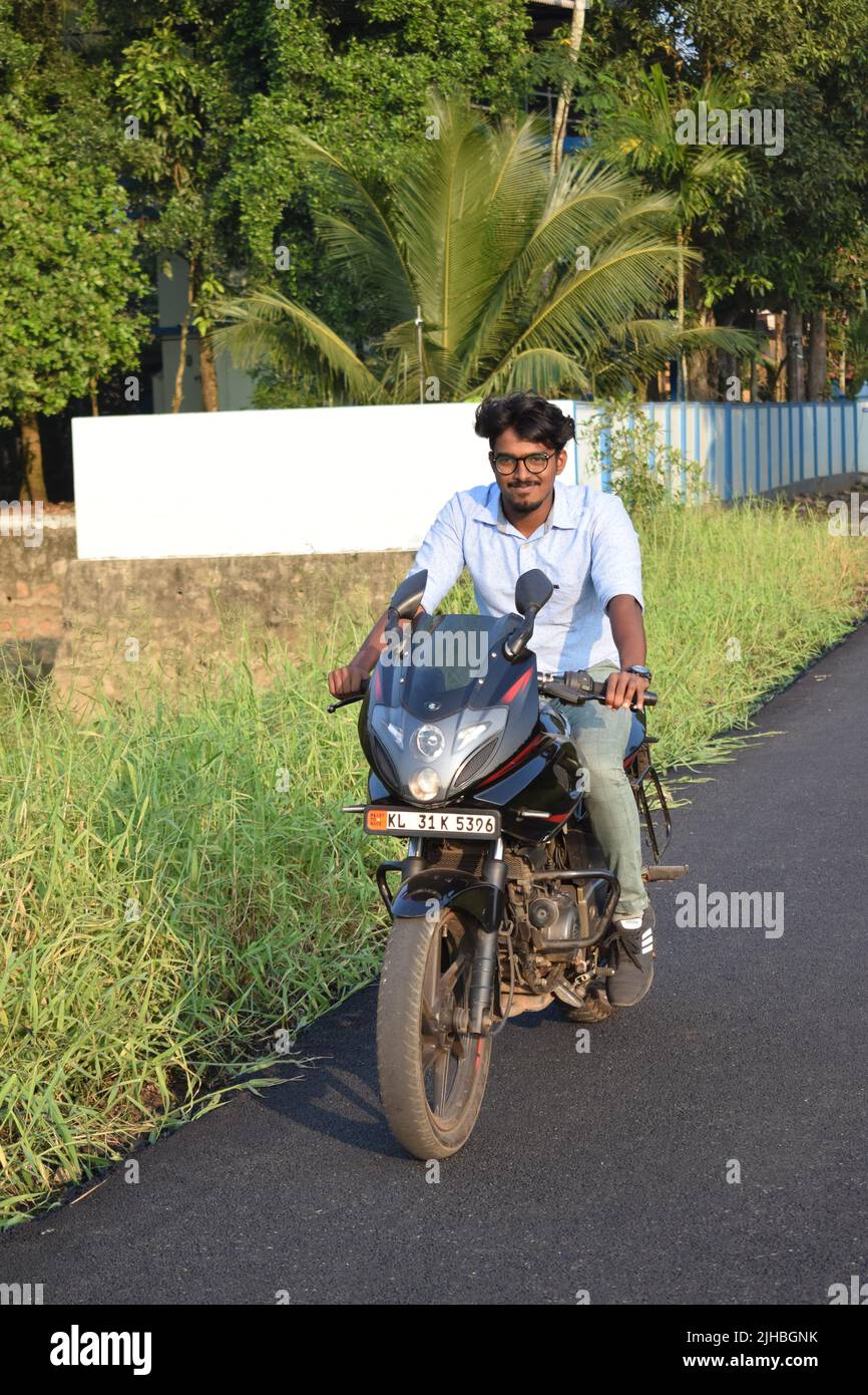 An indian young man riding a motorcycle near a paddy field Stock Photo ...