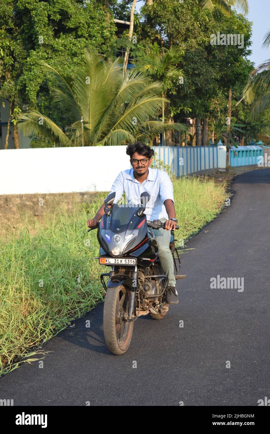An indian young man riding a motorcycle near a paddy field Stock Photo ...