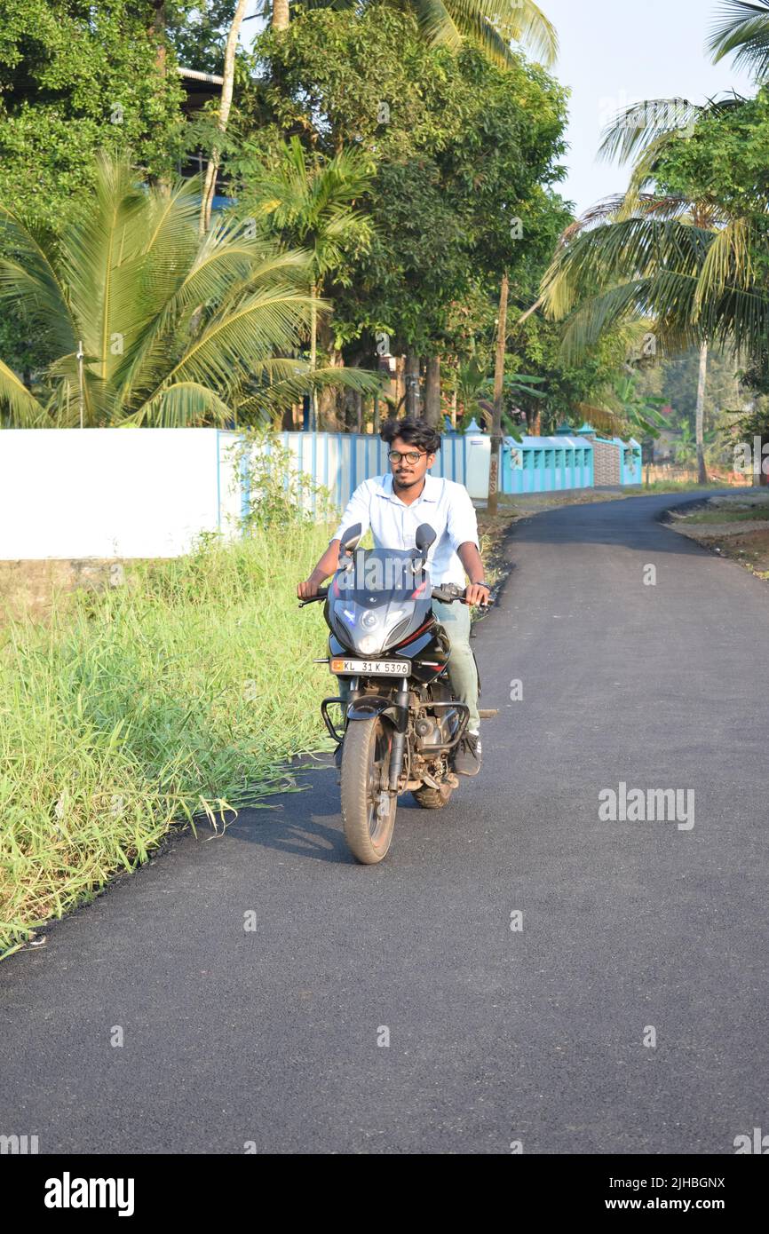 An indian young man riding a motorcycle near a paddy field Stock Photo ...