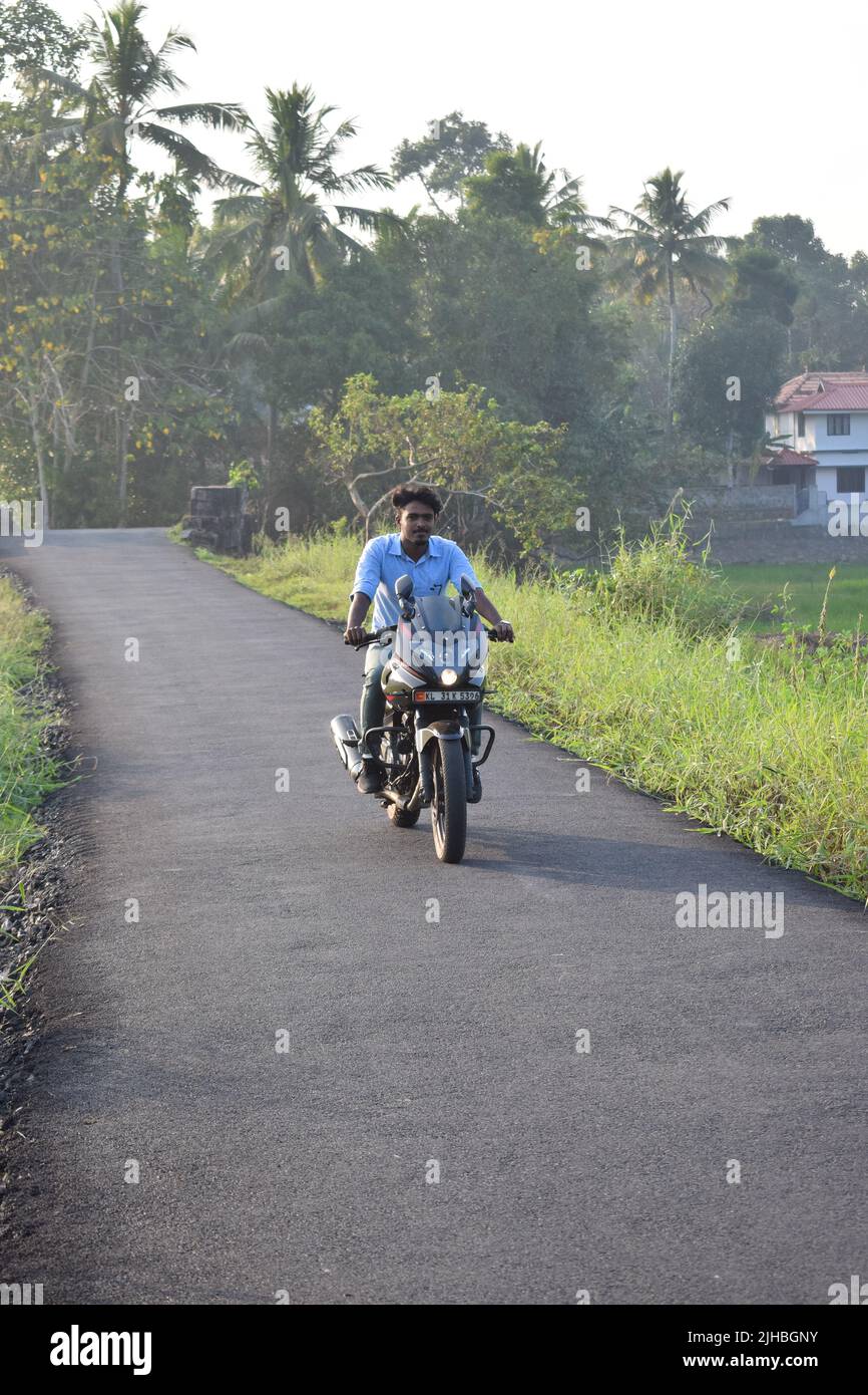 An indian young man riding a motorcycle near a paddy field Stock Photo ...