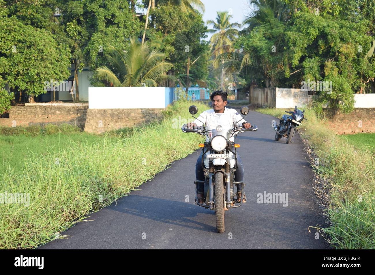 An indian young man riding a motorcycle near a paddy field Stock Photo ...