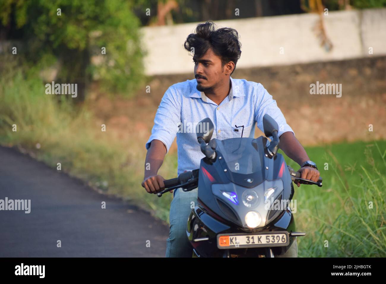 An indian young man riding a motorcycle near a paddy field Stock Photo ...