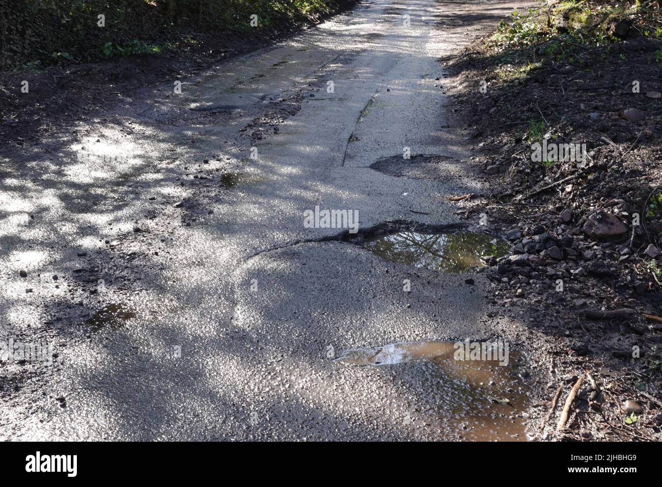 Dangerous potholes on a country lane in the UK Stock Photo - Alamy