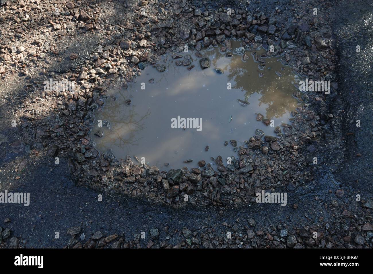 A dangerous pothole filled with water Stock Photo - Alamy