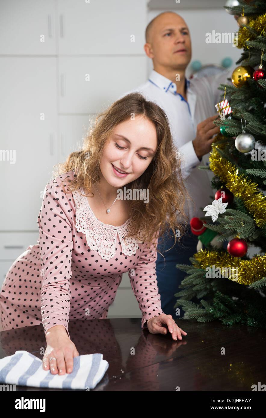 Friendly family tidying up the room before Christmas Stock Photo - Alamy