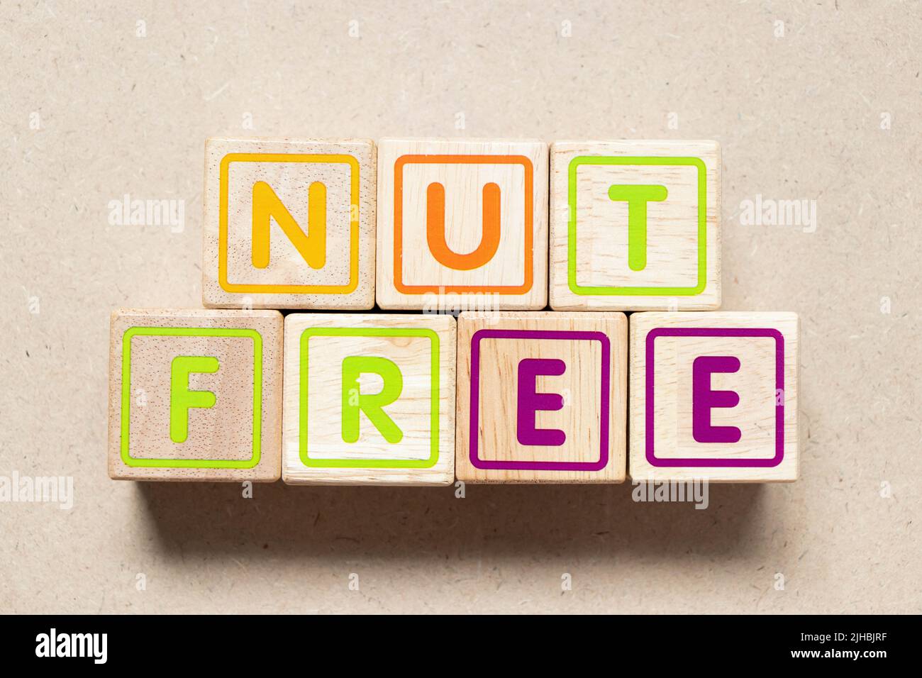 Color letter block in word nut free on wood background Stock Photo - Alamy