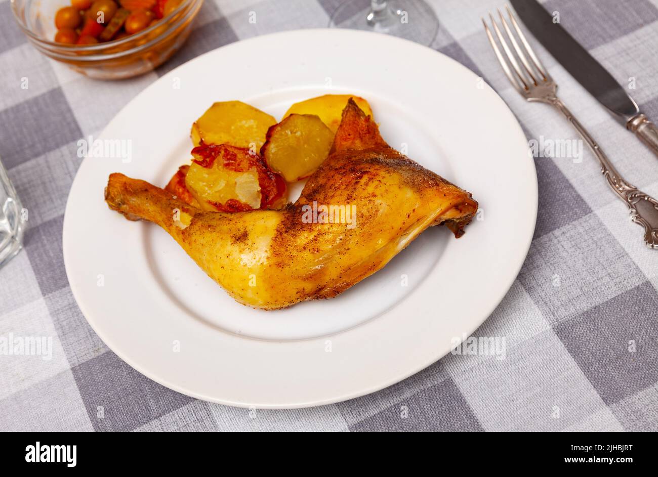 Portion of roasted chicken leg with potatoes Stock Photo - Alamy