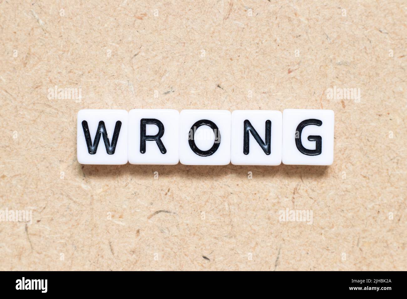 White tile alphabet letter with word wrong on wood background Stock Photo - Alamy
