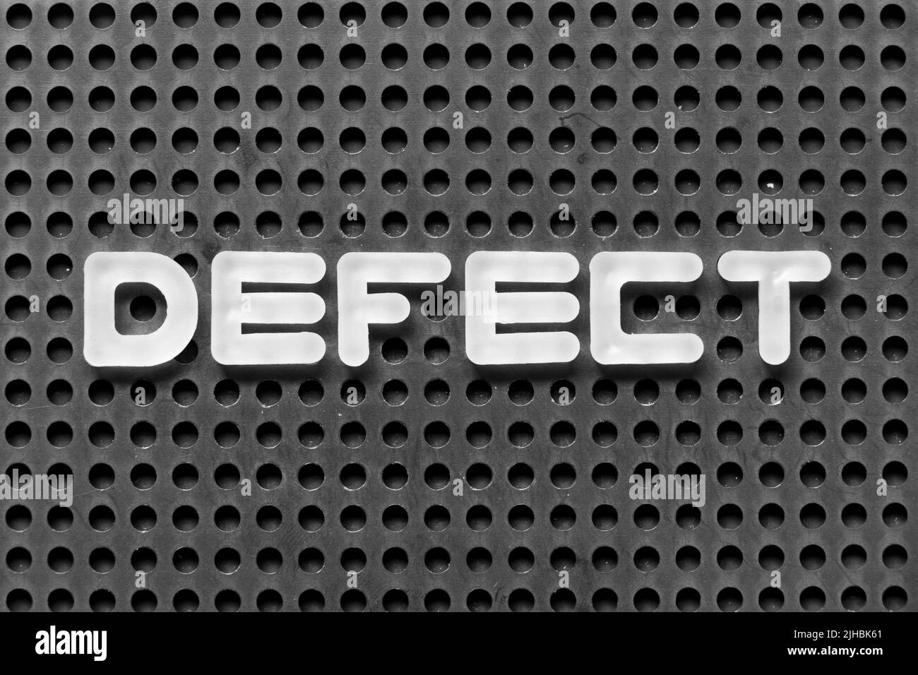 White alphabet letter in word defect on black pegboard background Stock ...