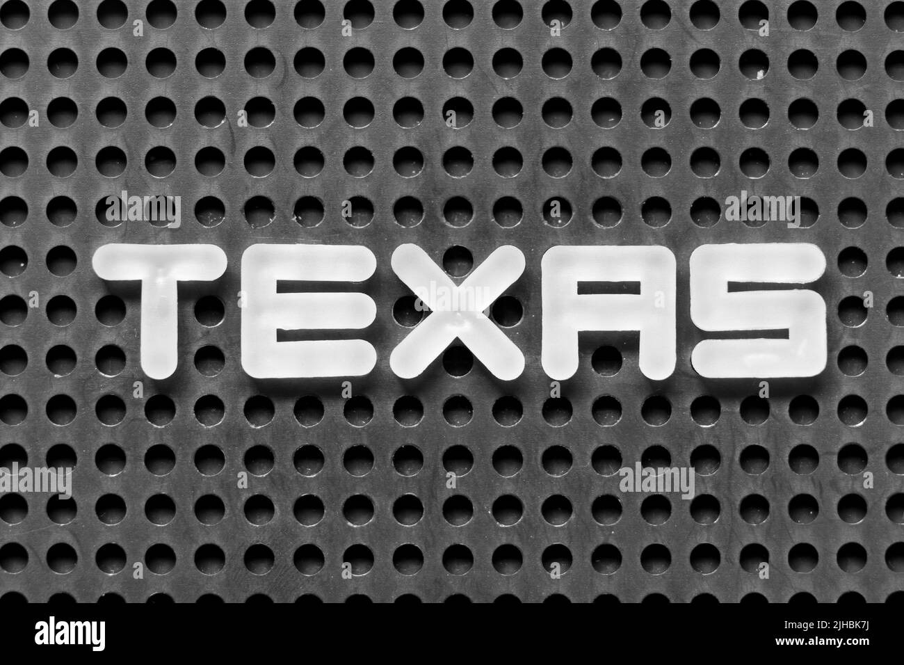 White alphabet letter in word texas on black pegboard background Stock ...