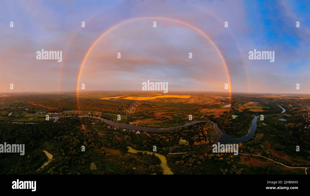 Round rainbow over the river on a summer evening Stock Photo - Alamy