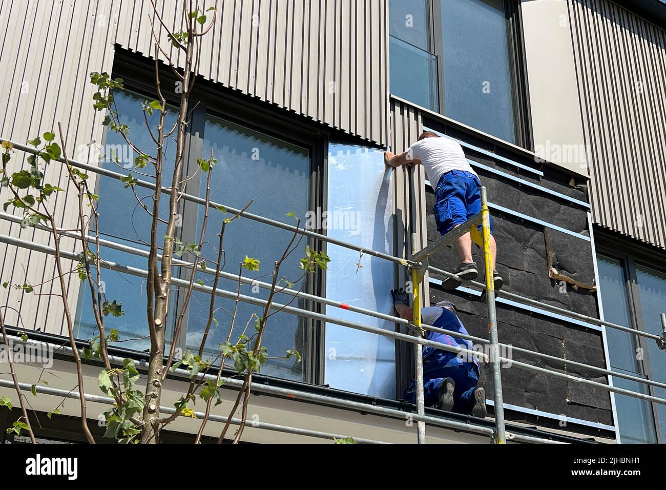 Munich, Deutschland. 15th July, 2022. Workers, craftsmen cladding a ...