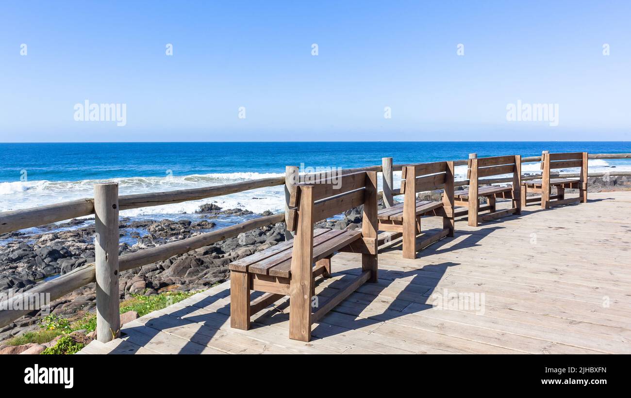 Beach ocean rocky coastline a public walkway with four sitting wood ...
