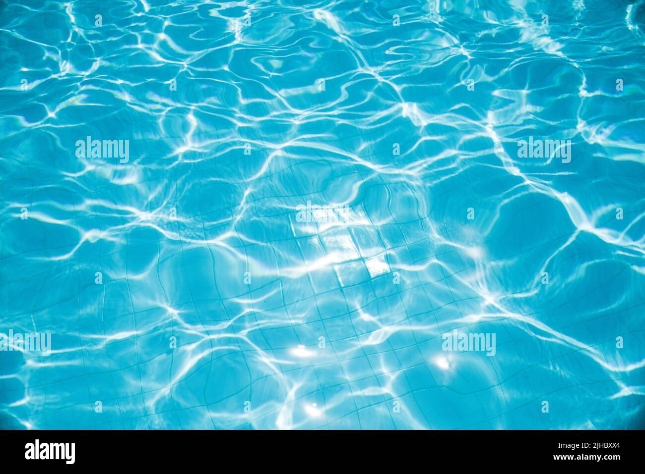 Transparent water in the pool with glare and waves, water abstract ...