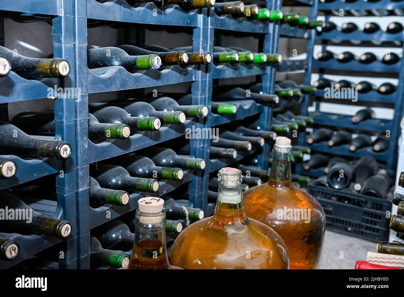 Bottled wines on the shelves inside an underground cellar Stock Photo ...
