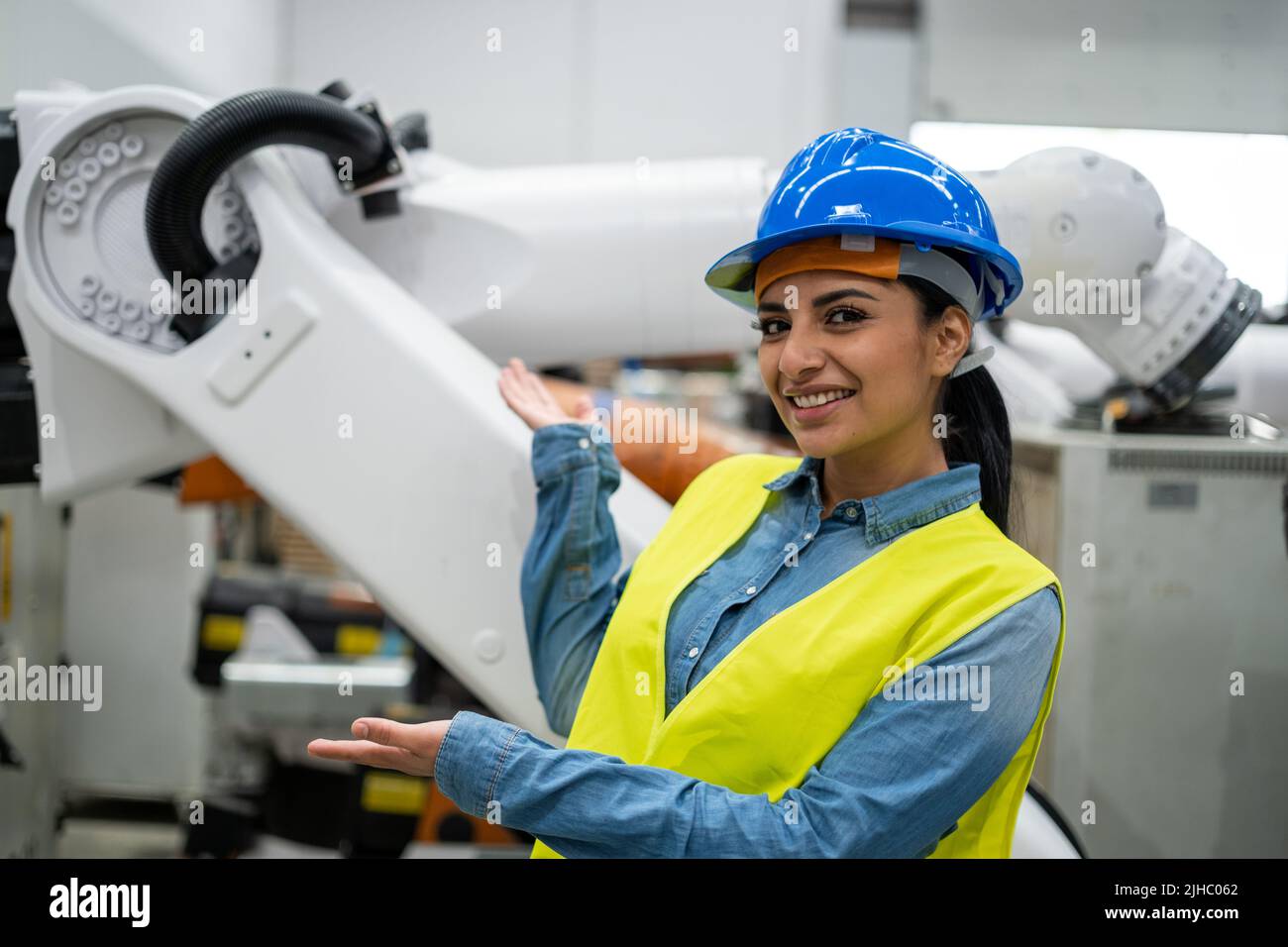 Young engineer showing the machines and robots of the manufacturing ...