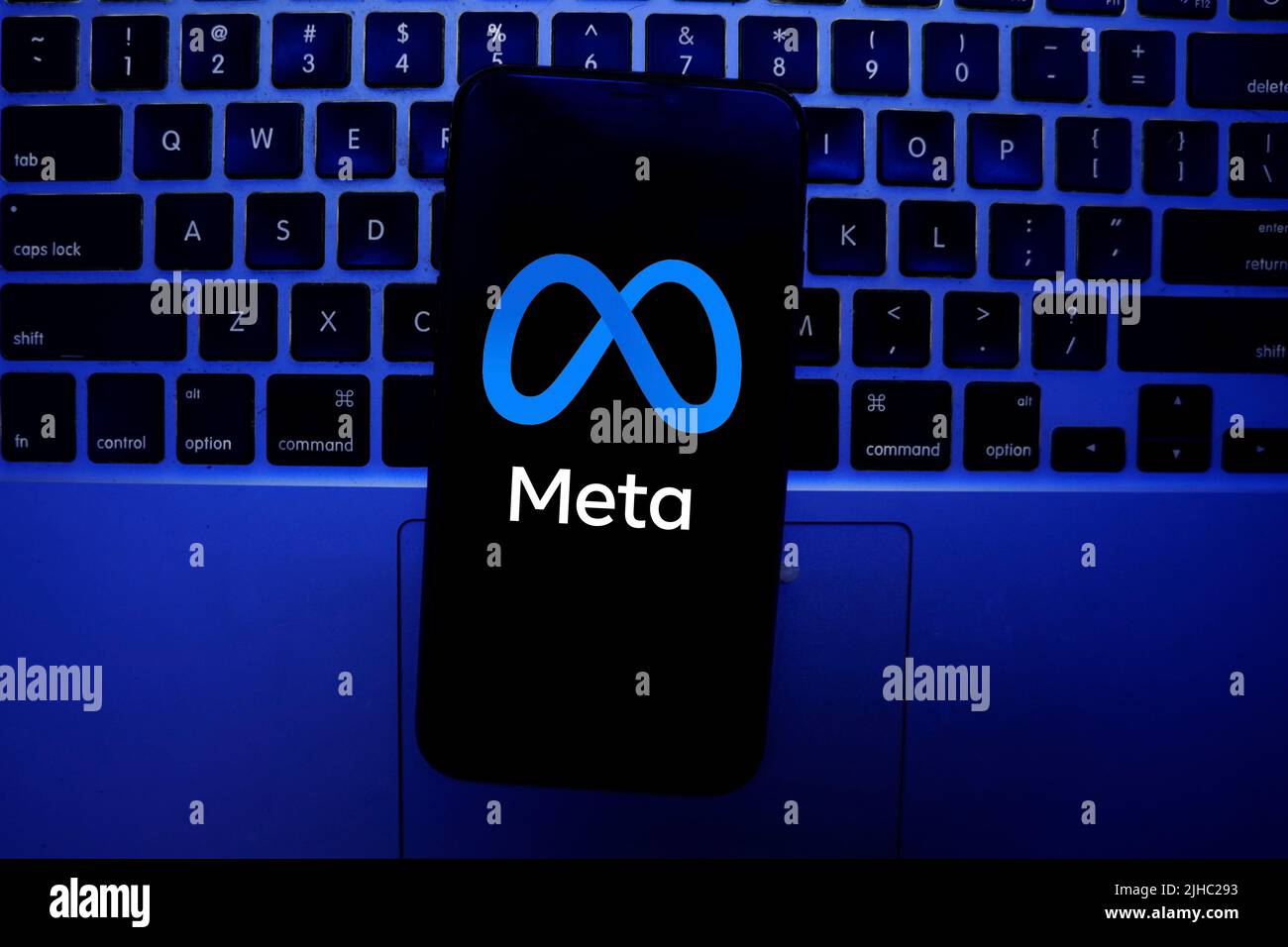 Smartphone with Meta or MetaVerse logo lies on wooden table with two ...