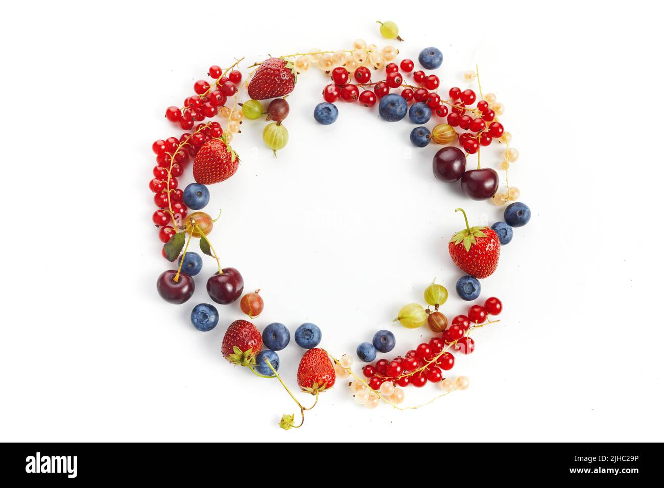 Various fresh summer berries round frame on white background. Top view ...