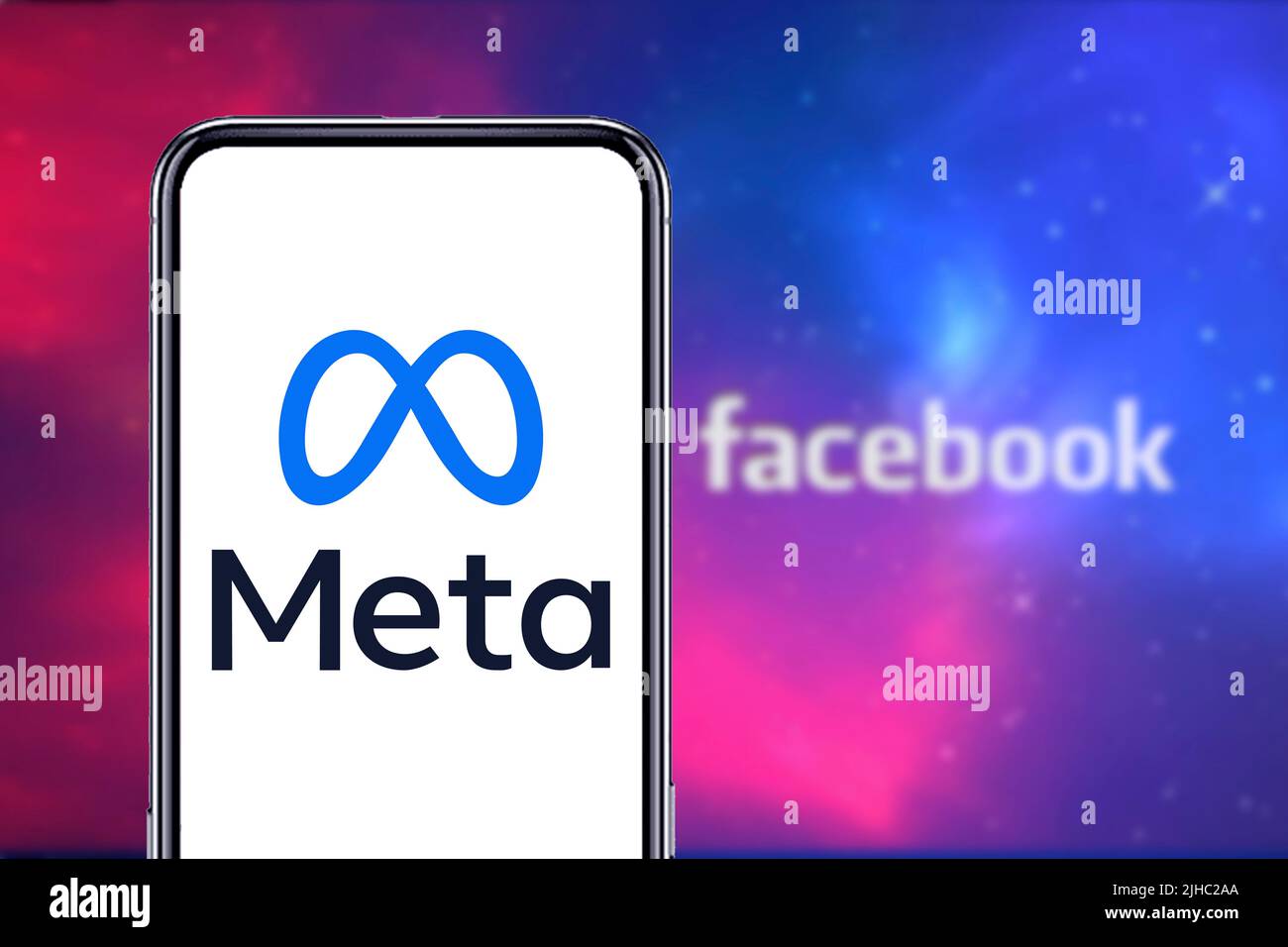 Smartphone with Meta or MetaVerse logo lies on wooden table with two ...