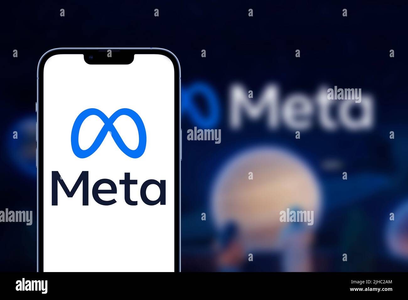 Smartphone with Meta or MetaVerse logo lies on wooden table with two ...