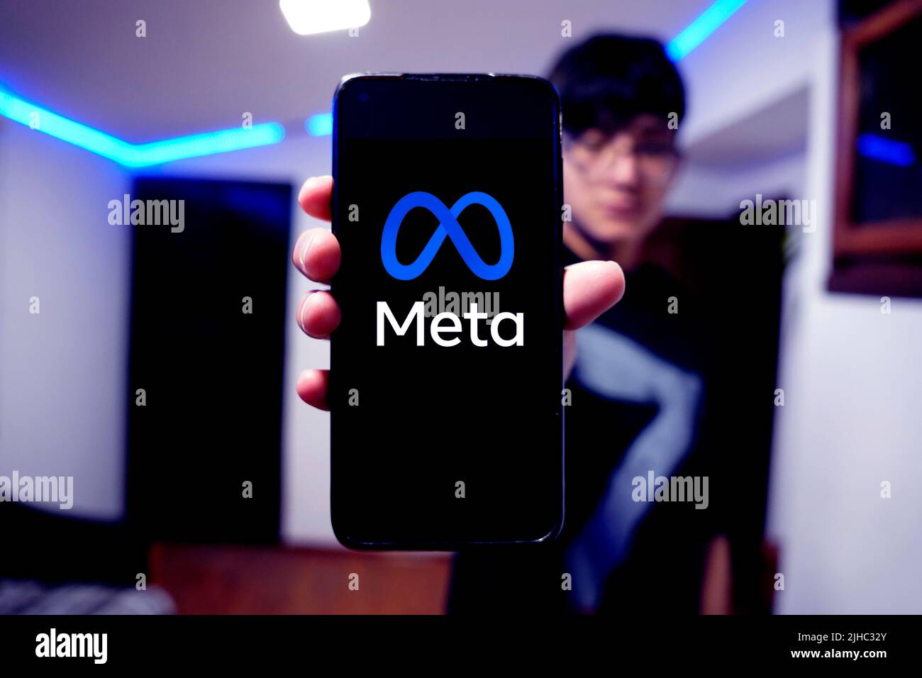 Smartphone with Meta or MetaVerse logo lies on wooden table with two ...