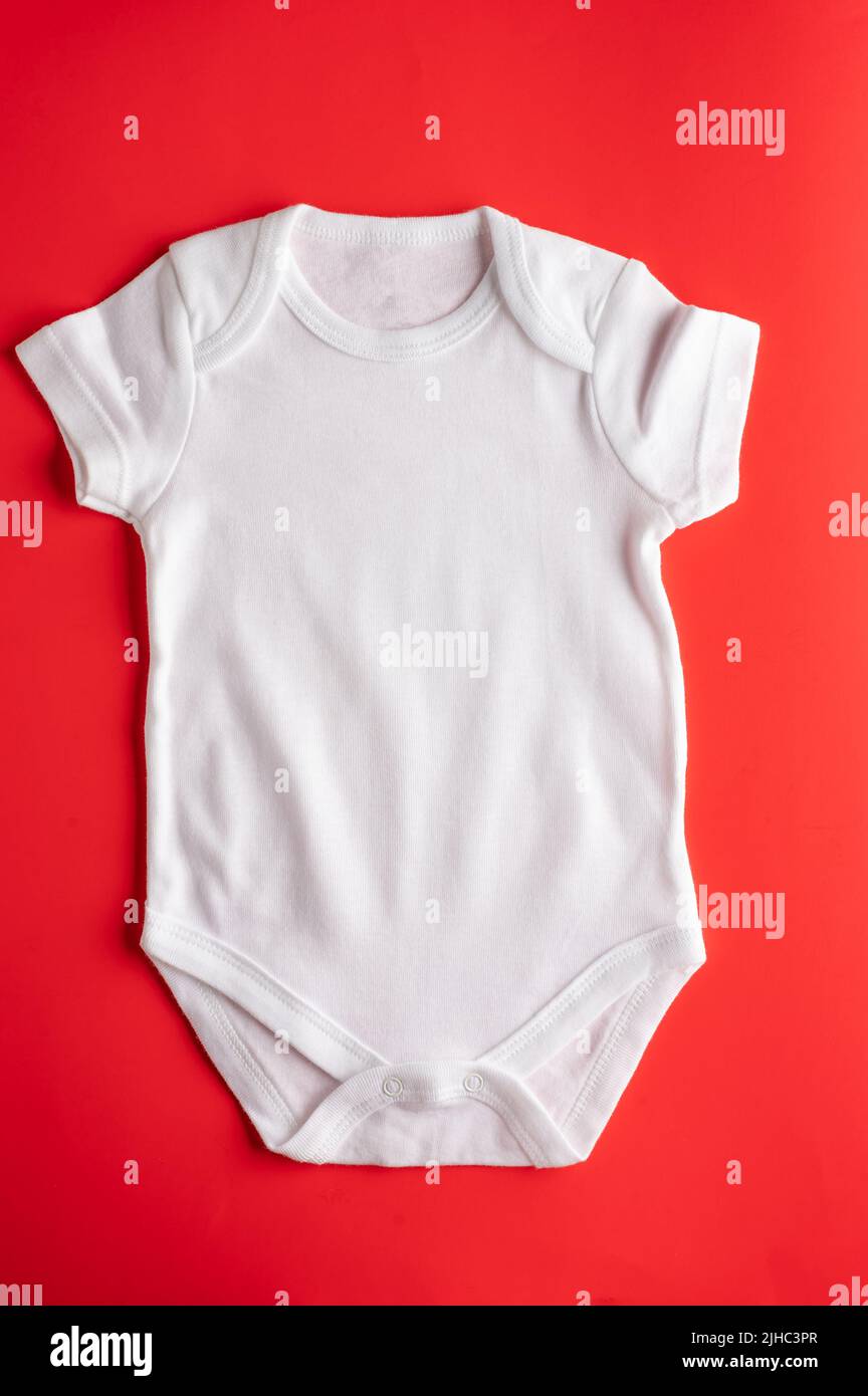 Flat lay mockup of white cotton bodysuit for little girls on red ...