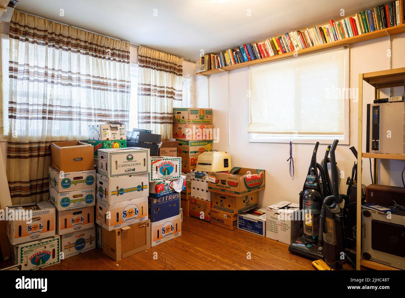 Boxes of stuff piled up agains the wall in a bedroom Stock Photo - Alamy