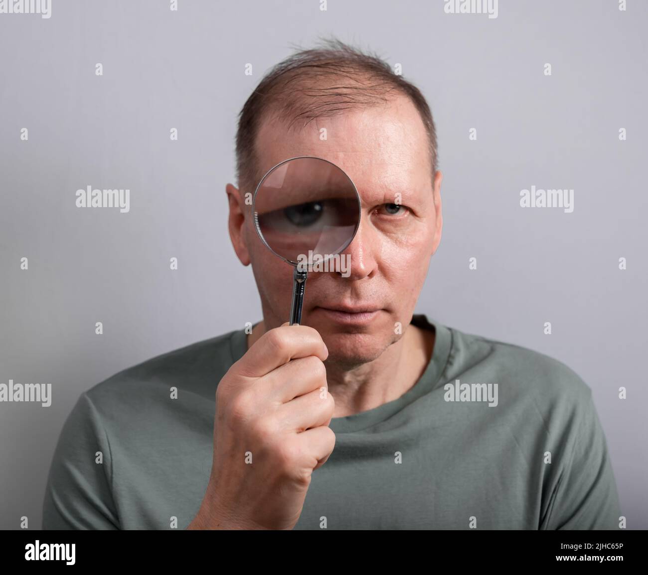 Man looking through magnifying lens. Psychology concept Stock Photo - Alamy