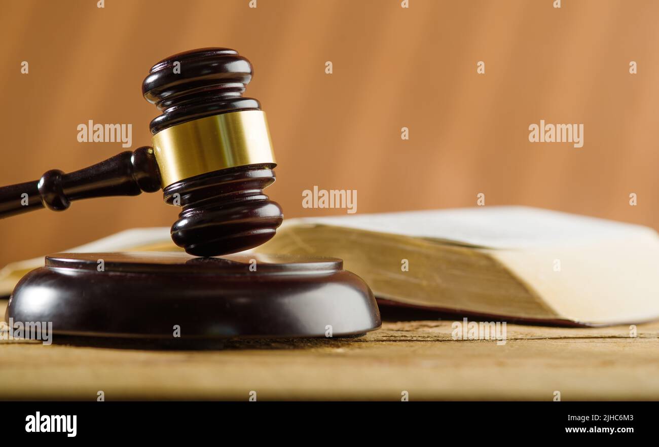 On a beige background, a wooden gavel of a judge and an open book ...
