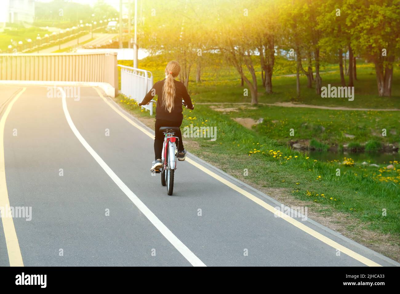 A child rides a bike on a bike path. Cyclist child or teenage girl ...