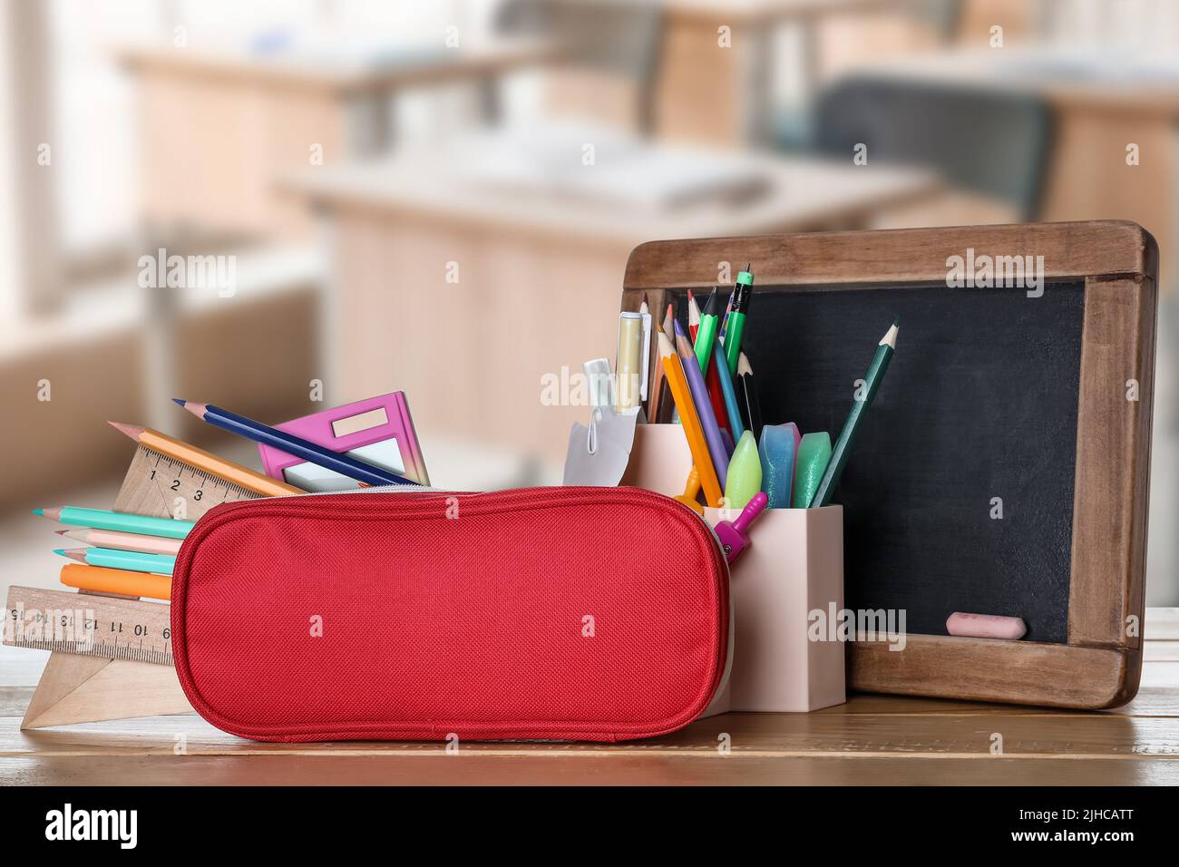 Set of school stationery on table in classroom Stock Photo - Alamy