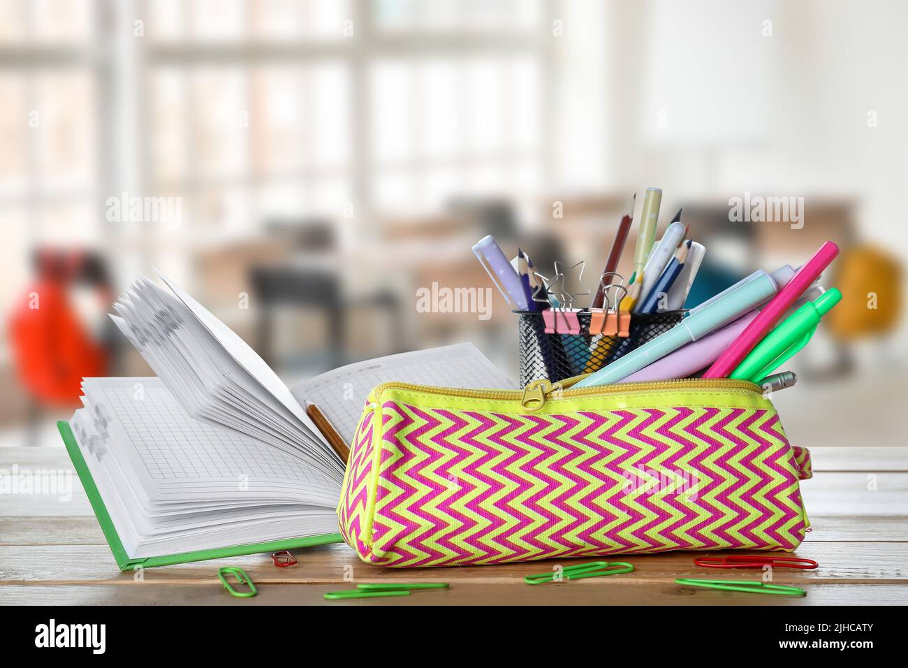 Set of school supplies on table in classroom Stock Photo - Alamy