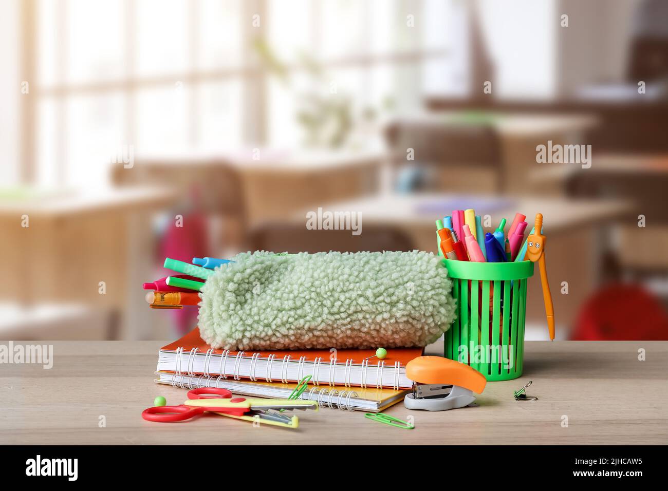 Set of school stationery on table in classroom Stock Photo - Alamy