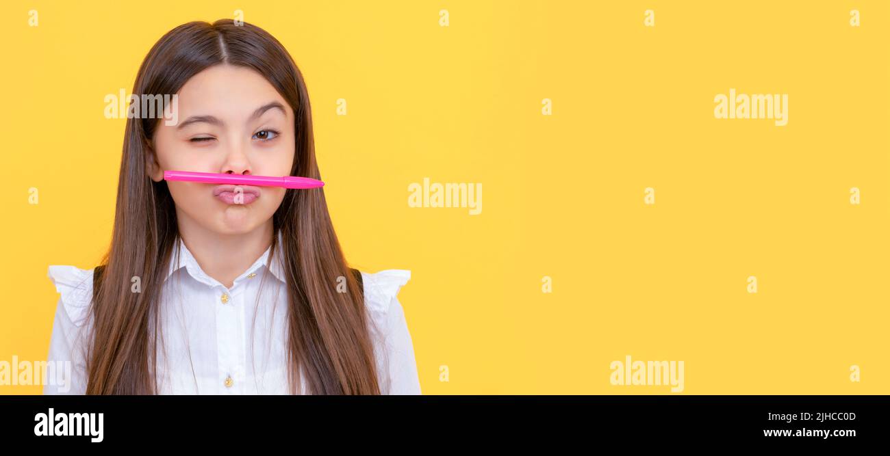 Playful winking girl child hold pen as mustache yellow background ...