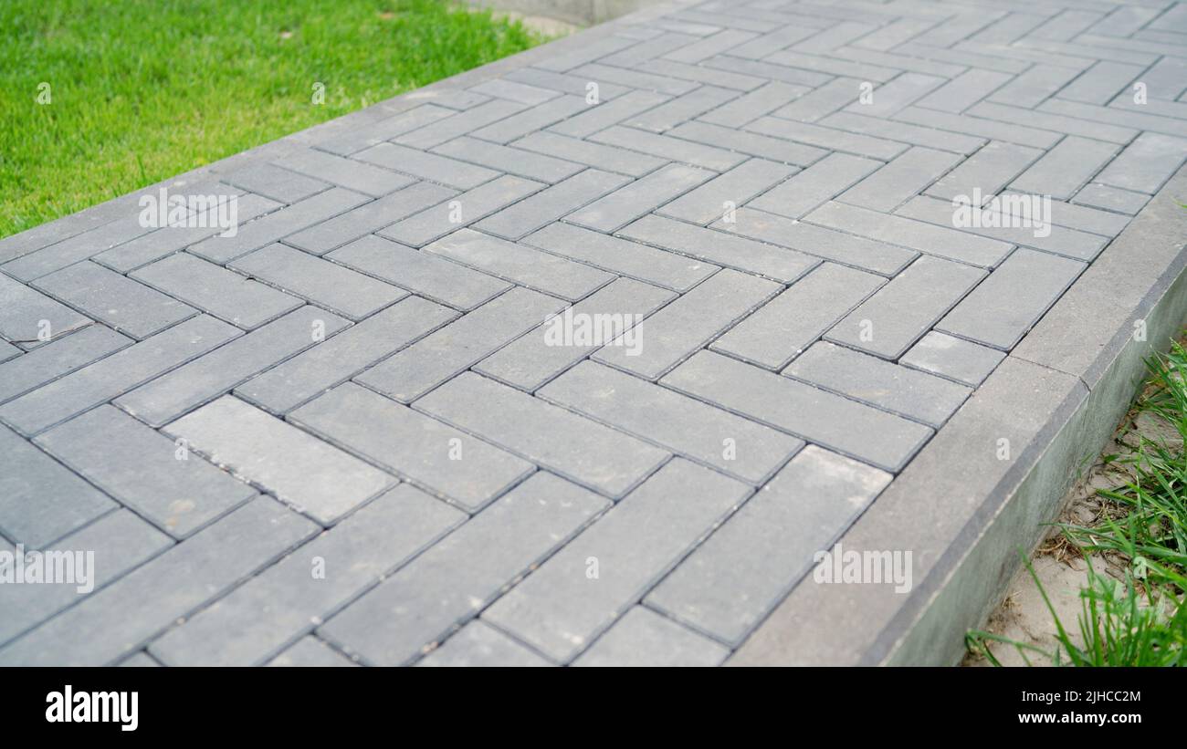 Gray tiles on the sidewalk in sunny weather. Paving stones. Concept of ...