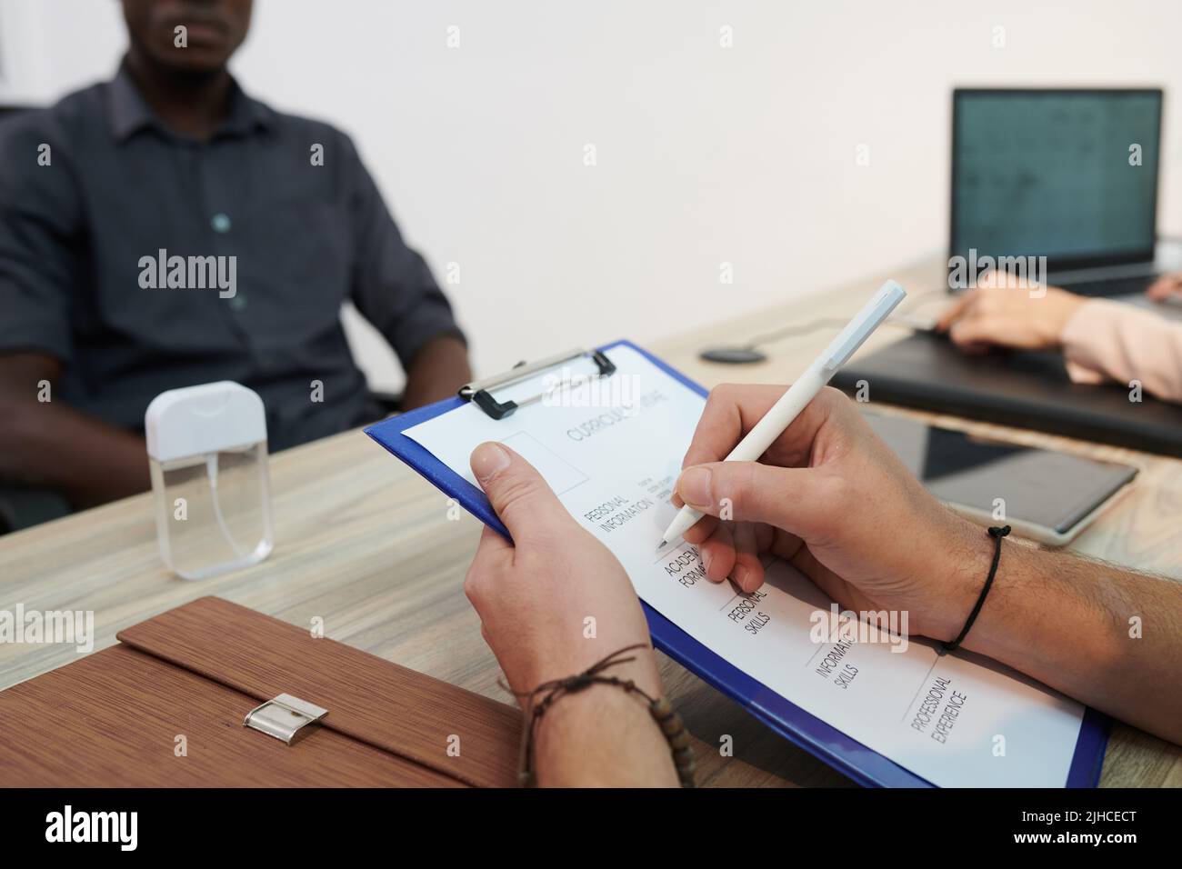 Hands of job candidate filling cv form and writing down personal data ...
