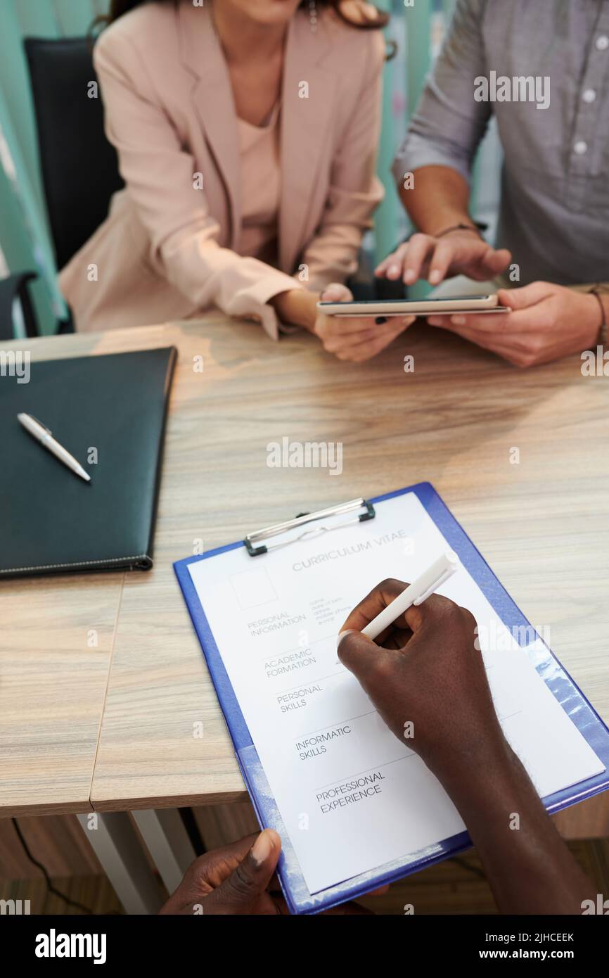Closeup image of Black job candidate filling curriculum vitae form ...