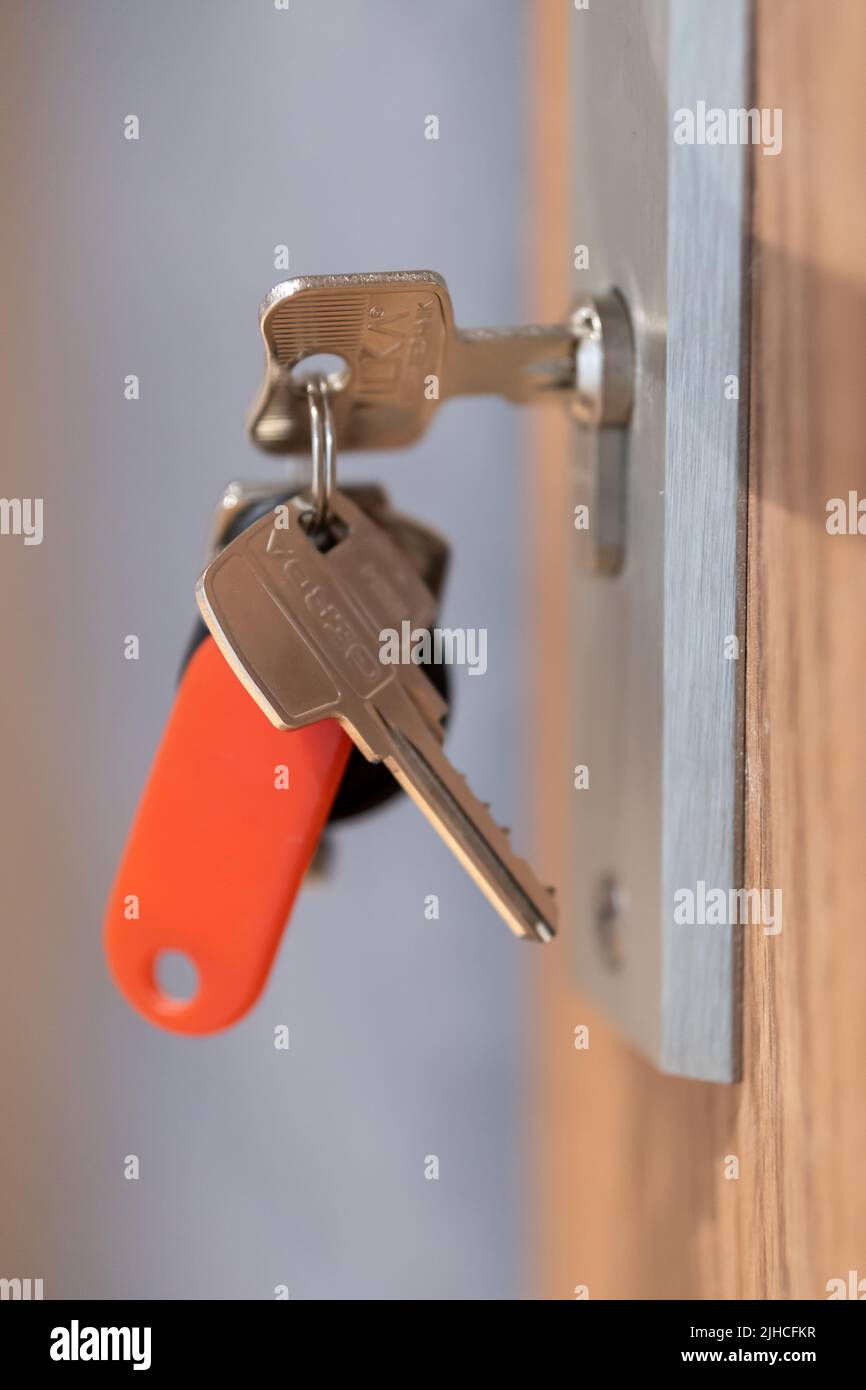The close-up of Gerda brand keys hanging on an entrance door, vertical ...