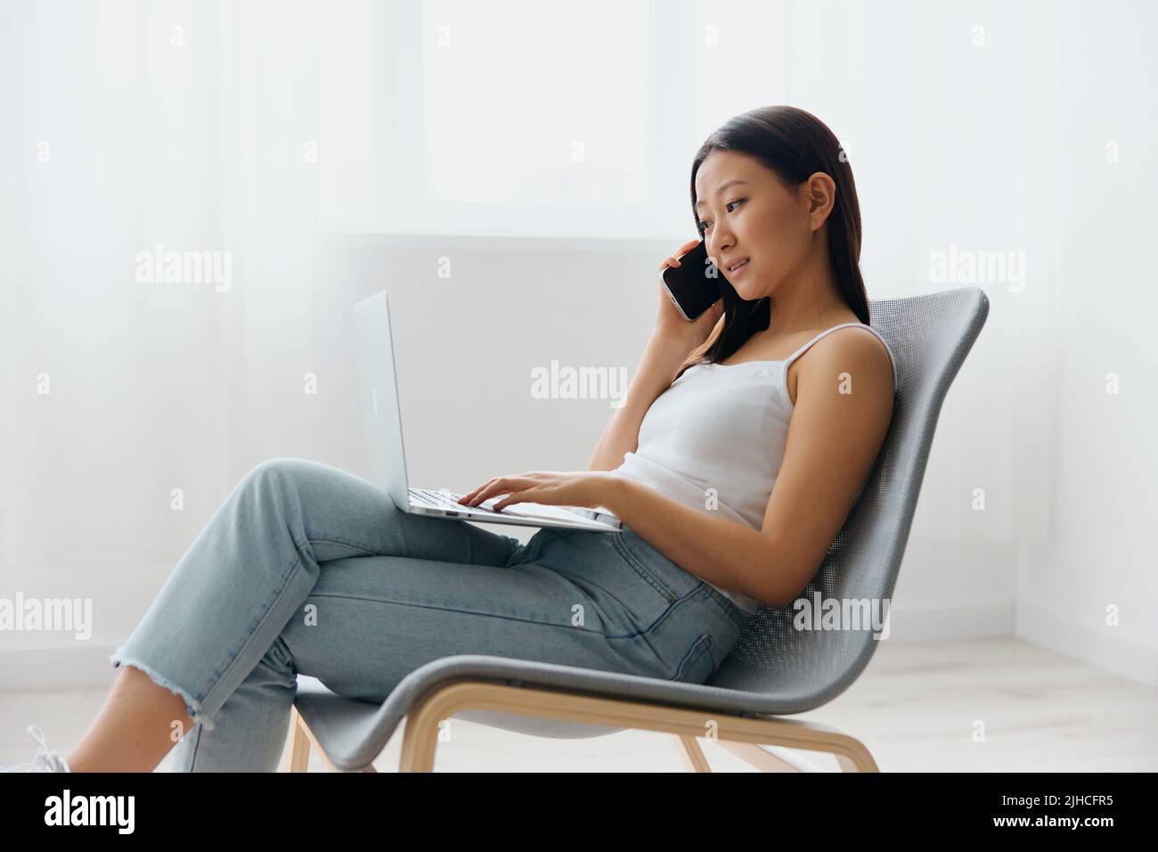 Happy speaking tanned lovely young Asian woman talk with client creates ...