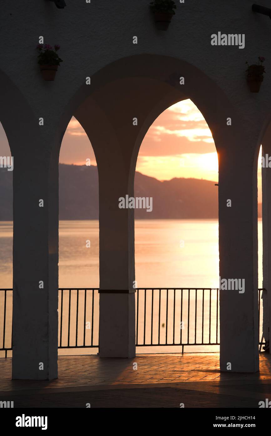 Beautiful sunset over lake through architectural built archways ...