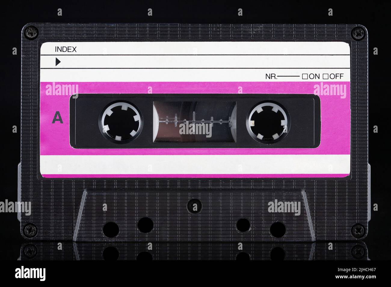 Red labeled retro vintage compact cassette A - side on black background ...